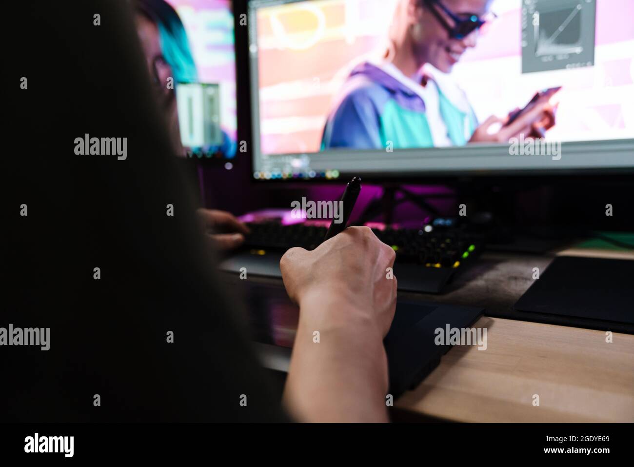 Back view of a young white man videographer working on a project with a ...