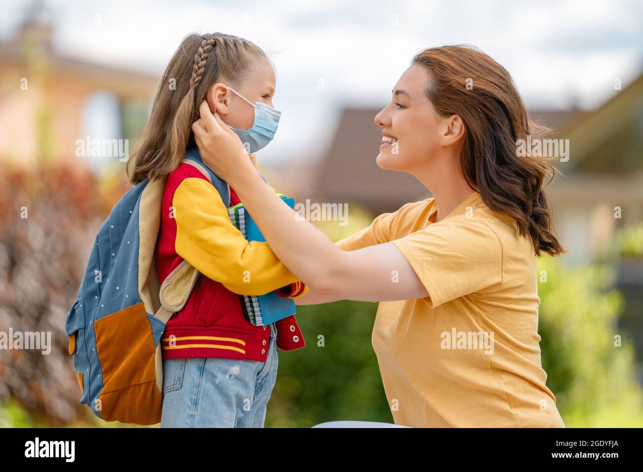 Parent and pupil of primary school going hand in hand. Woman and girl ...