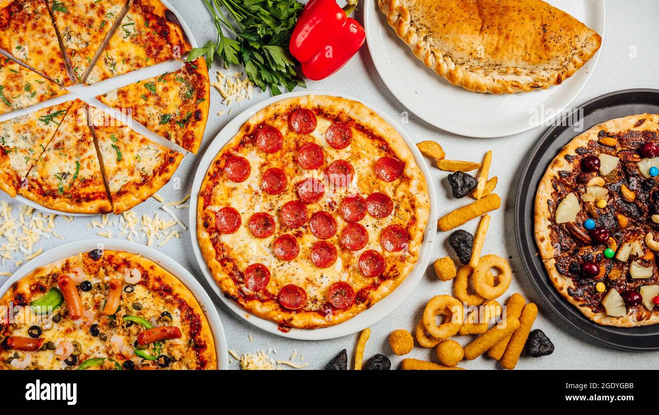 A top view of assorted pizzas and snacks on a table Stock Photo - Alamy