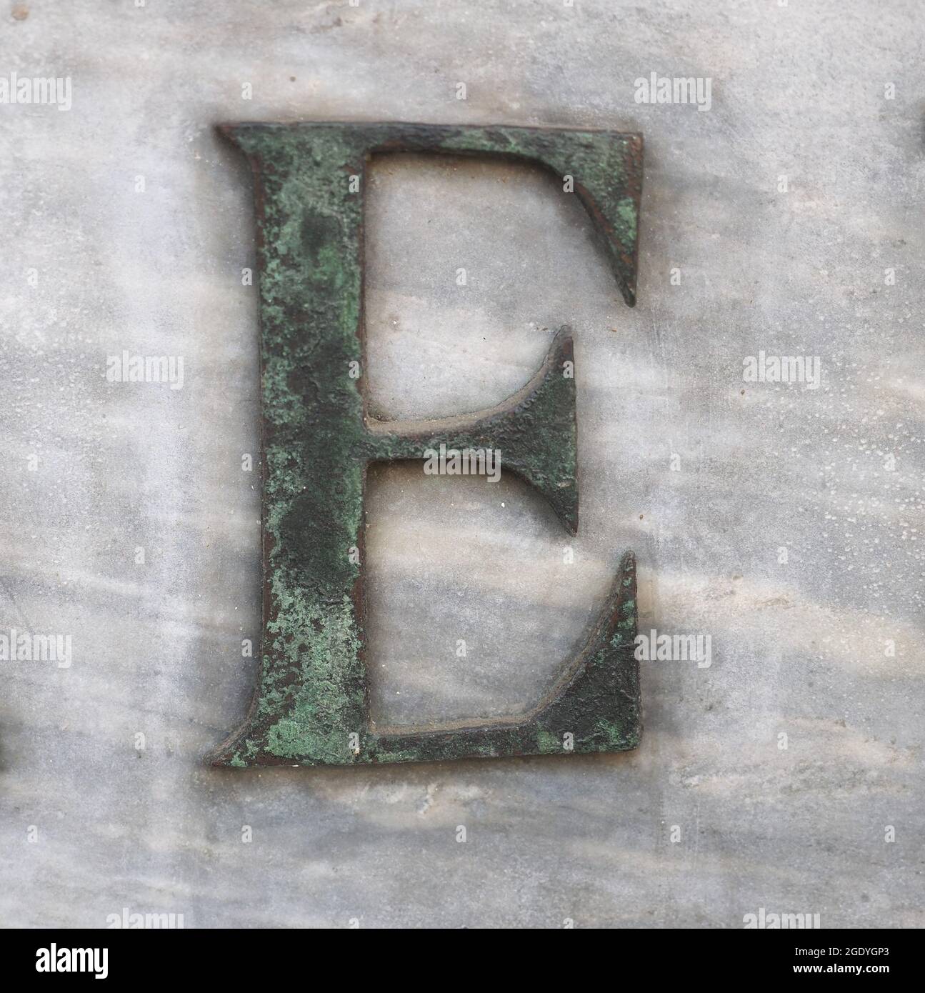 capital letter E cast in bronze on marble background Stock Photo - Alamy