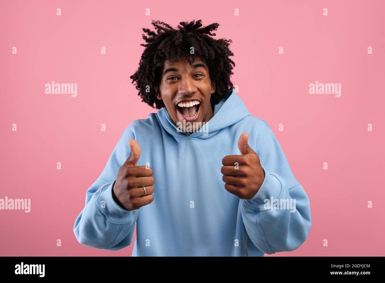 Excited African American teenager gesturing thumbs up with both hands ...