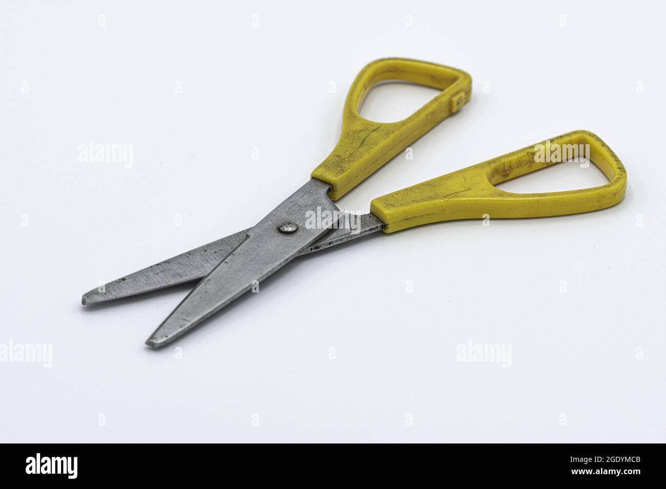 A closeup shot of a dirty yellow scissors on a white backgrou Stock ...