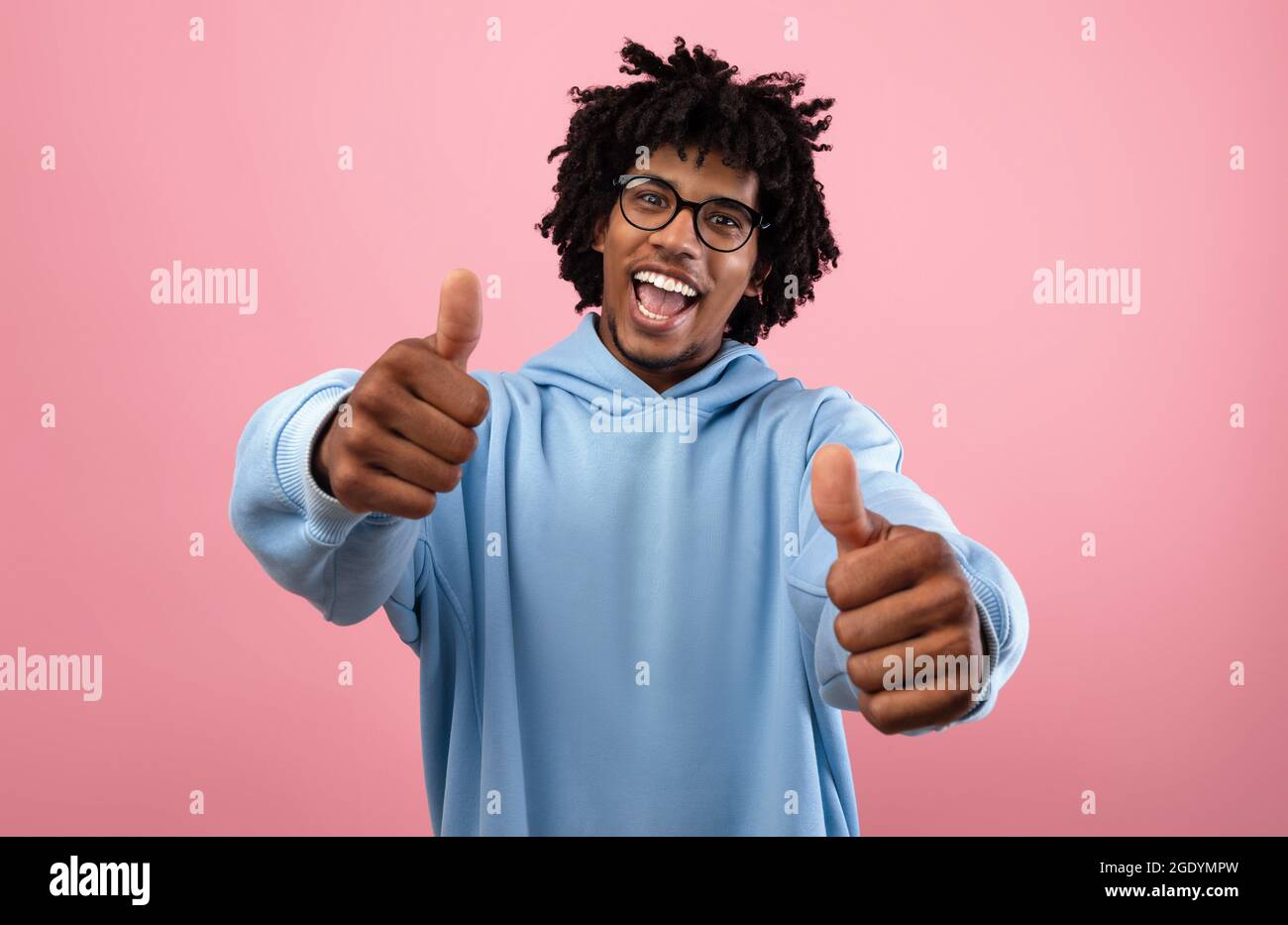 Funky Afro teen guy in glasses showing thumbs up with both hands ...