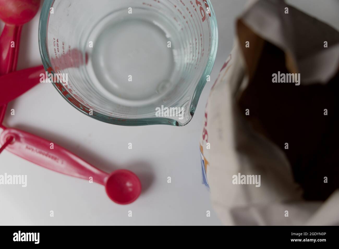 A top view of set of measuring spoons and measuring cup with flour ...