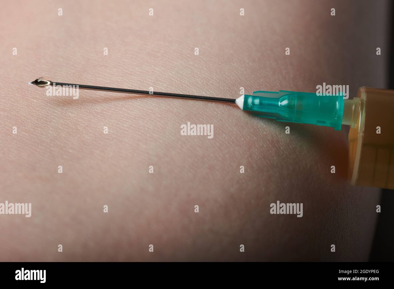 Drug addiction theme. Metal neddle syringe on human skin background ...