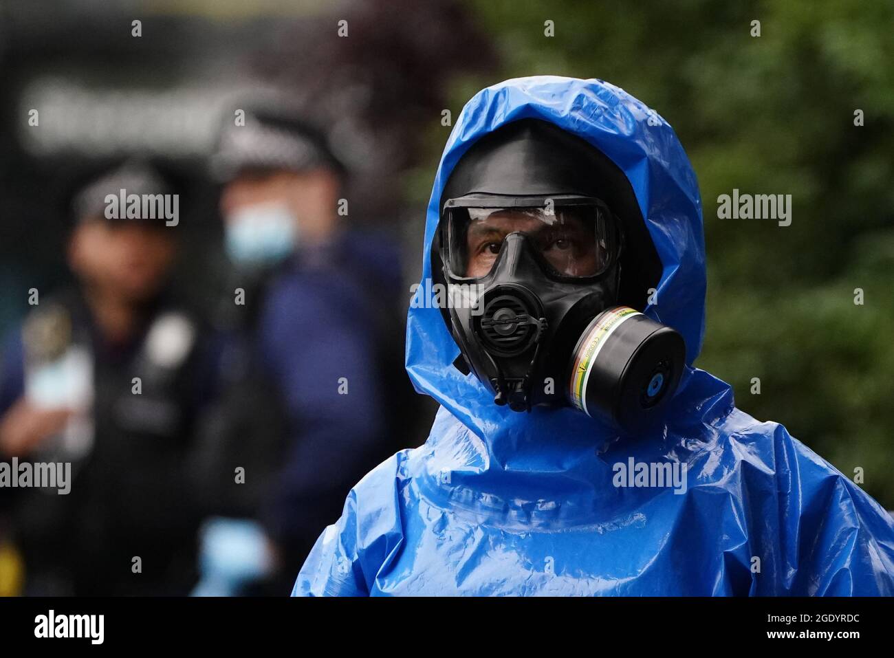 Police officers in bio-hazard suits and breathing apparatus searching a ...