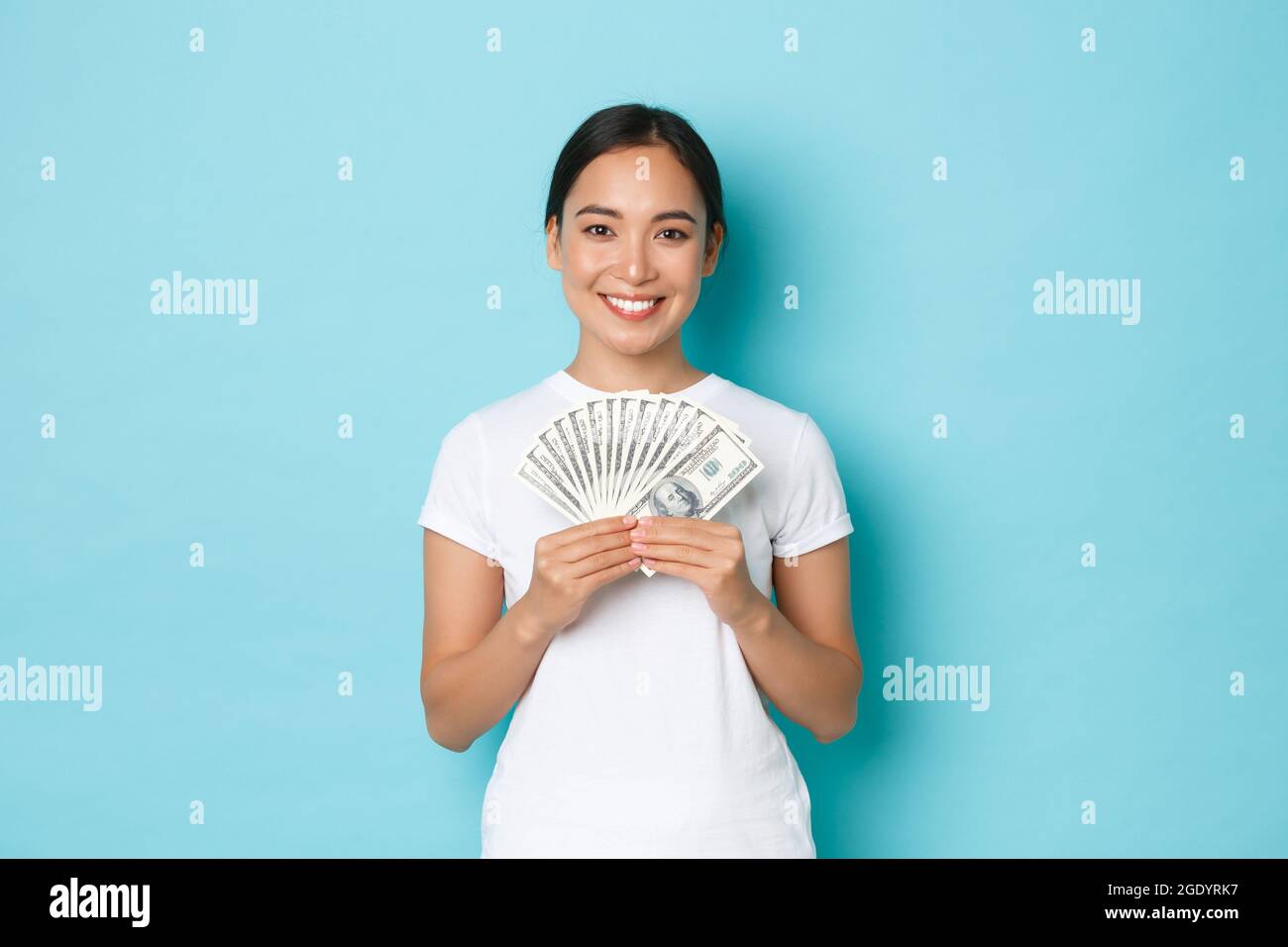 Shopping, money and finance concept. Smiling lucky asian female holding ...