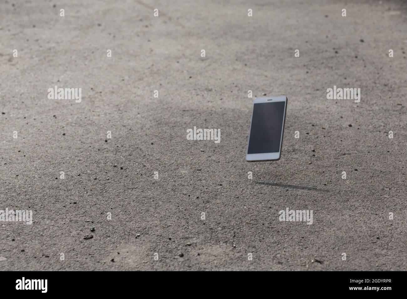 Broken screen mobile phone lies on ground Stock Photo - Alamy