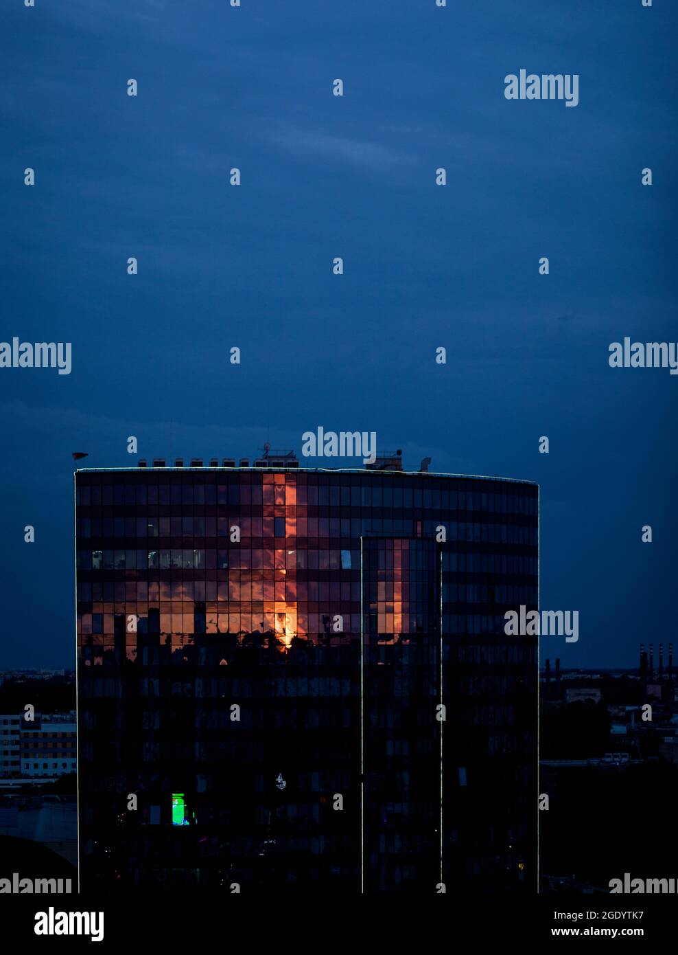 Facade of modern glass building at sunset. Warm and cool tone contrast ...