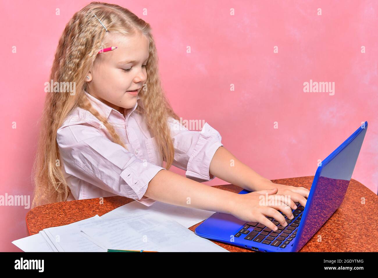 little girl is typing at the laptop. online learning Stock Photo - Alamy