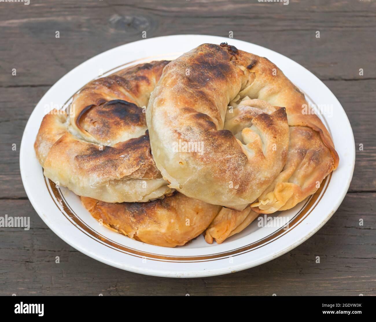 Delicious pies in a plate freshly cooked - Wooden Background Stock ...