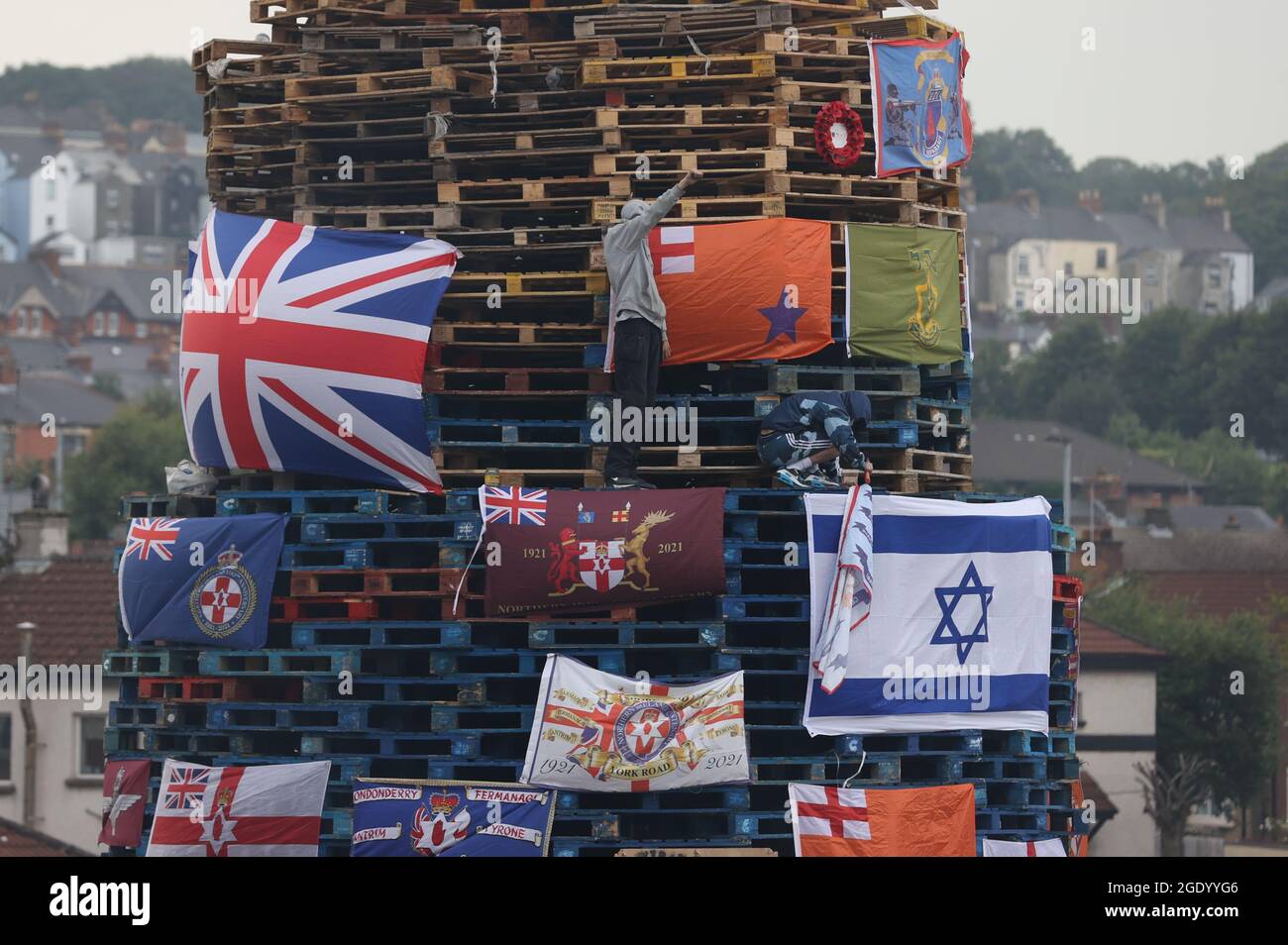 Flags are hung on a large bonfire being built to mark the Catholic ...