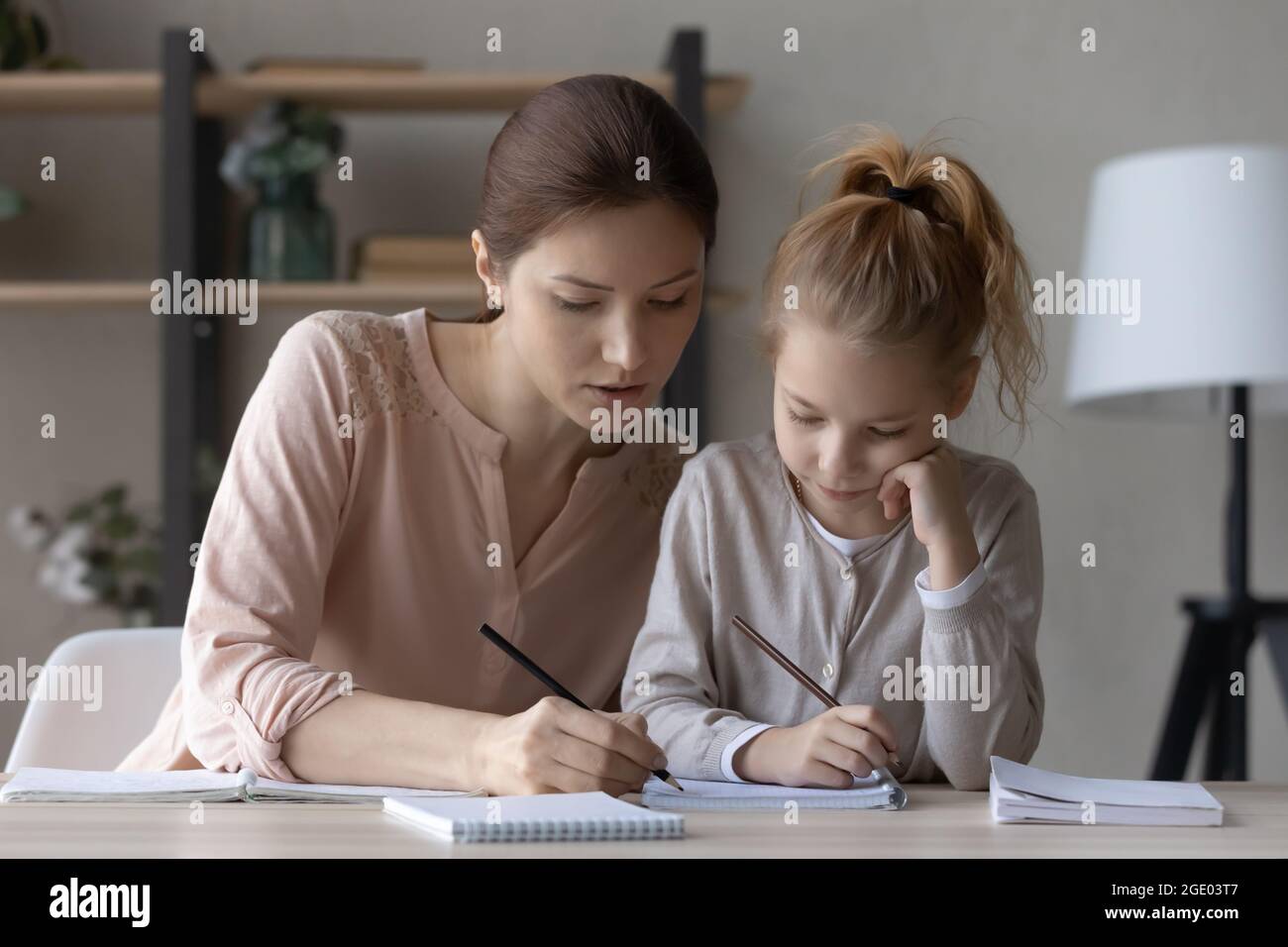 Caring mom and little daughter study together at home Stock Photo - Alamy
