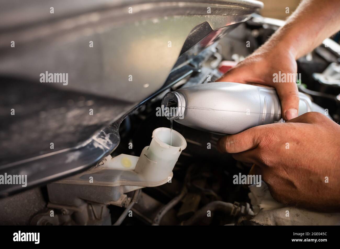 An auto mechanic pours brake fluid into the car Stock Photo - Alamy