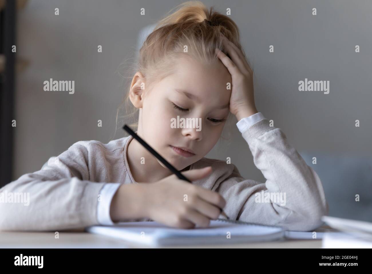 Bored small girl unmotivated to study at home Stock Photo - Alamy