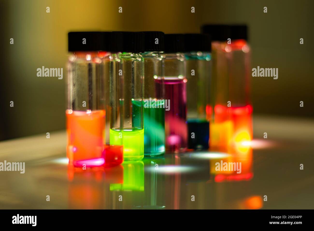 Various colourful reagents in glass vials on UV light in a ...