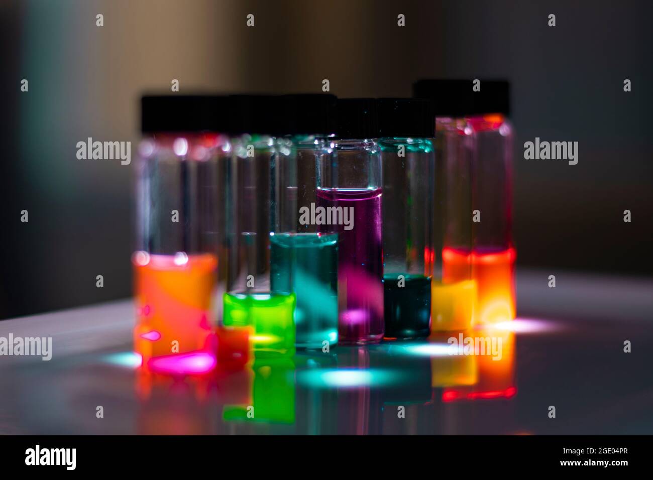 Various colourful reagents in glass vials on UV light in a ...
