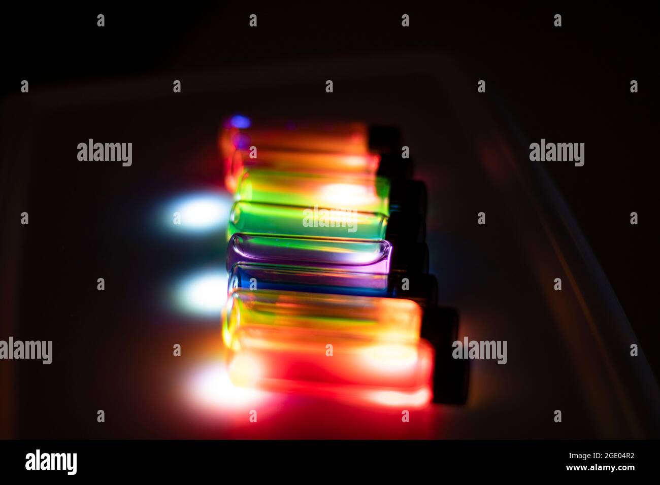 Various colourful reagents in glass vials on UV light in a ...