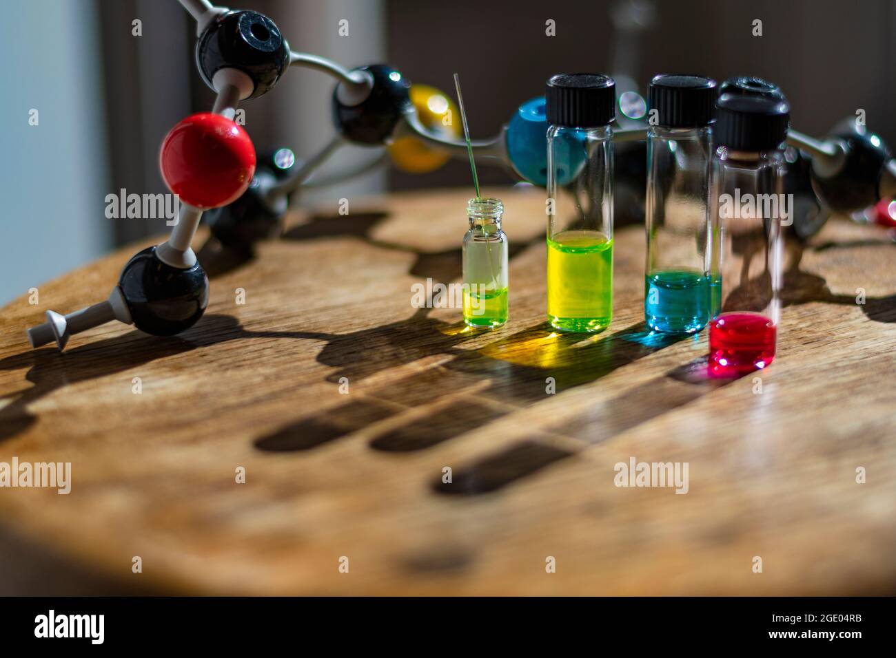 Colourful solutions in glass vials under the light with molecule model ...