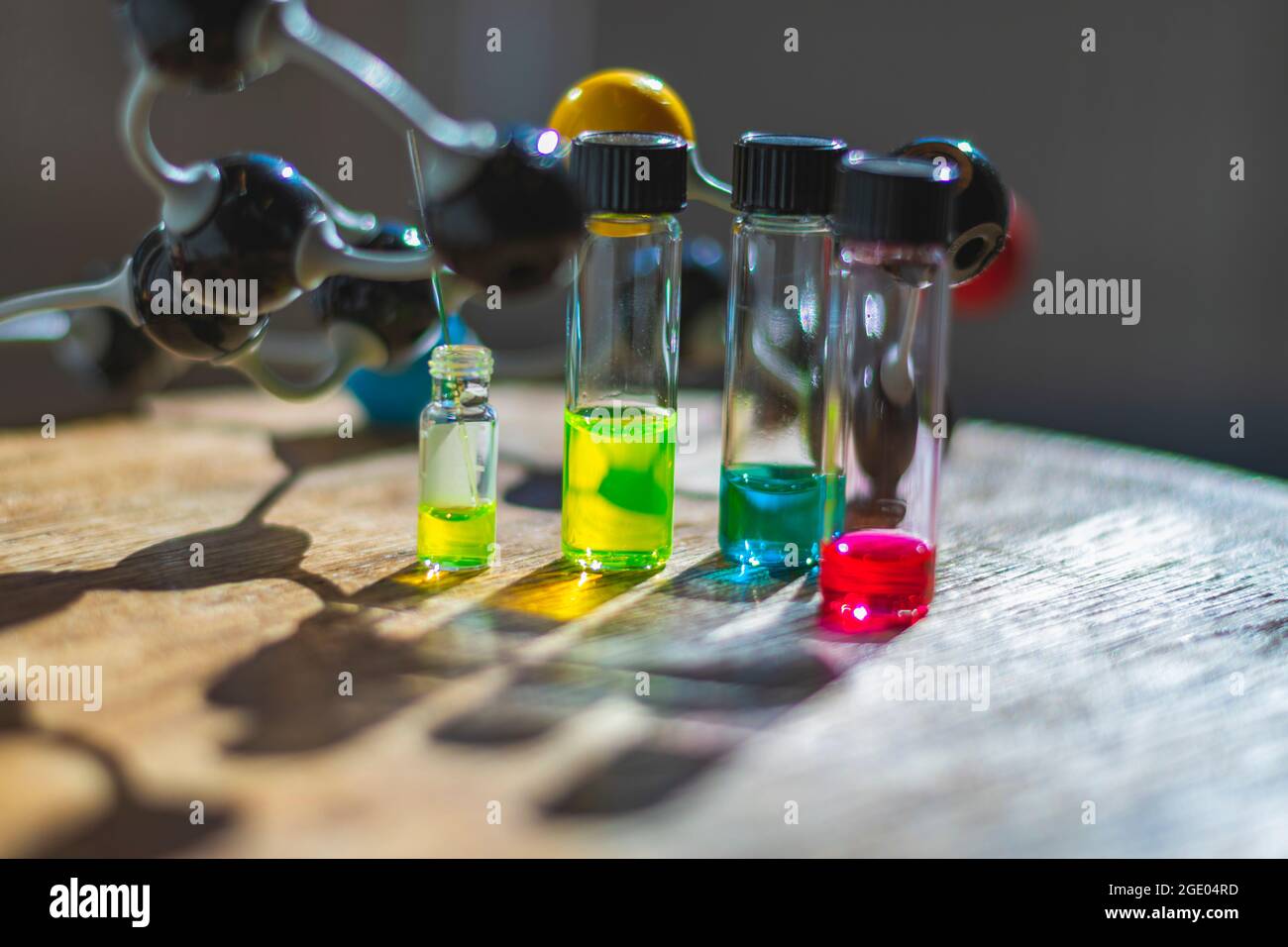 Colourful solutions in glass vials under the light with molecule model ...