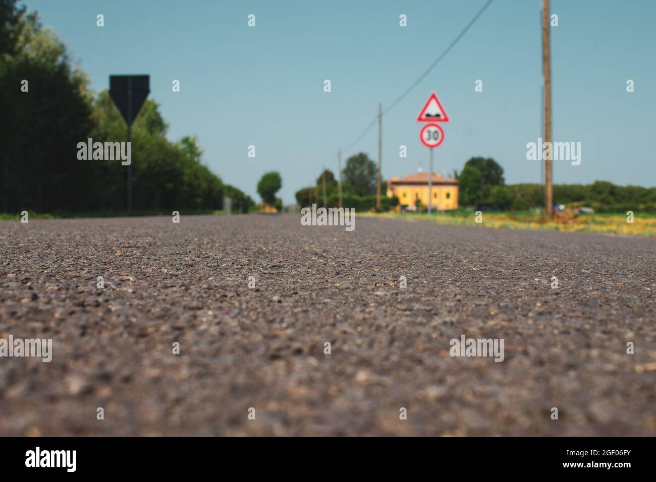 Low angle view on an asphalt road. Road signs and trees on the ...