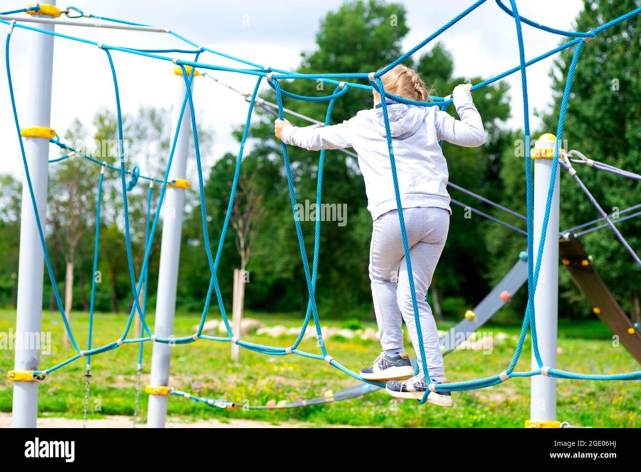 Little girl climbing in an adventure park. The girl loves to climb in ...
