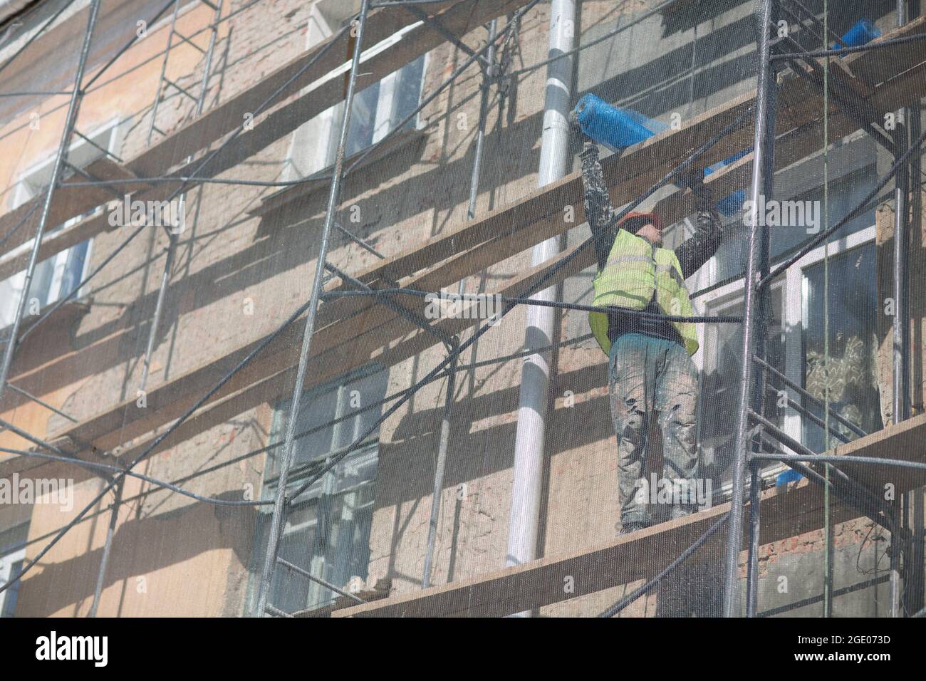 Worker on Scaffolding on building in the city Stock Photo - Alamy