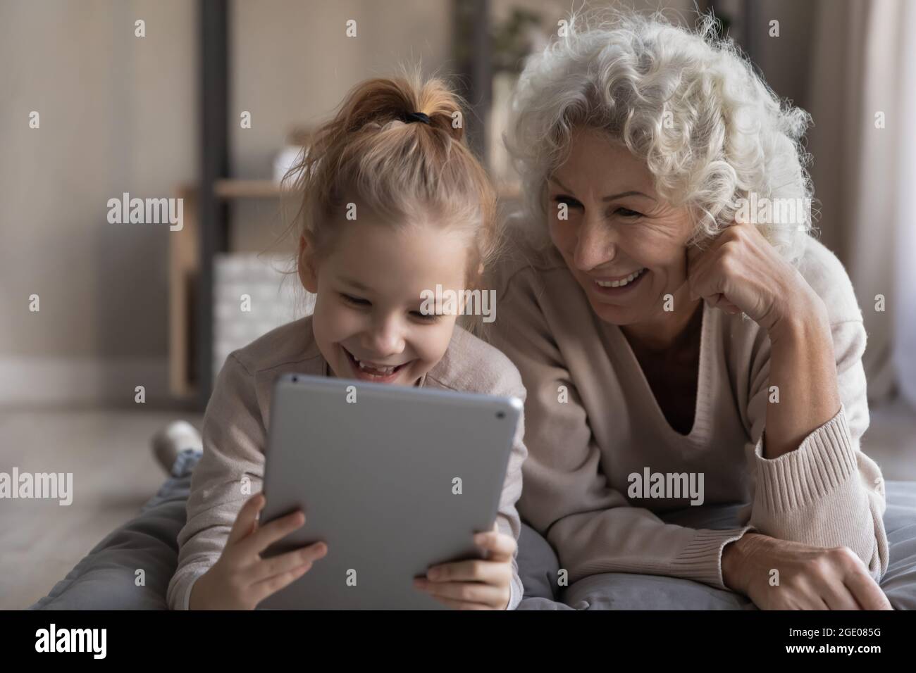 Happy old grandma and small granddaughter use tablet Stock Photo - Alamy