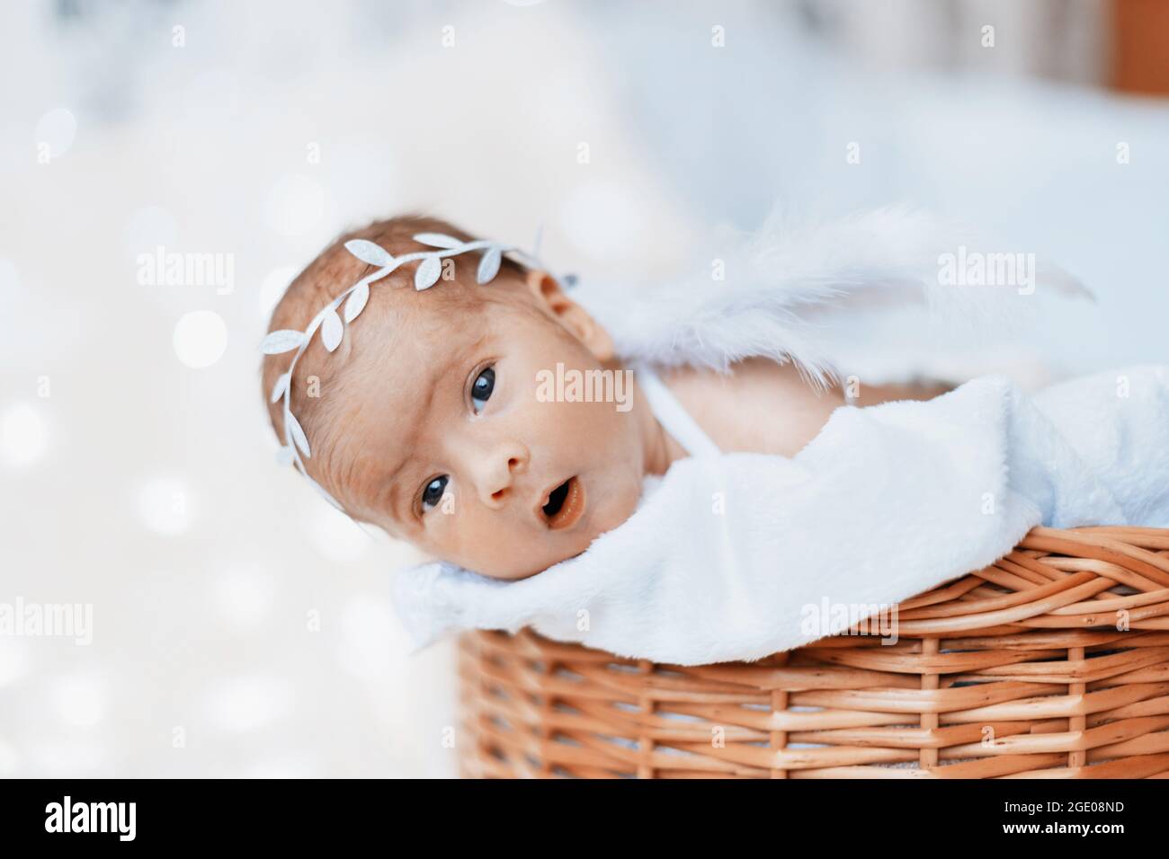 cute newborn baby angel looking out of the baby basket Stock Photo - Alamy