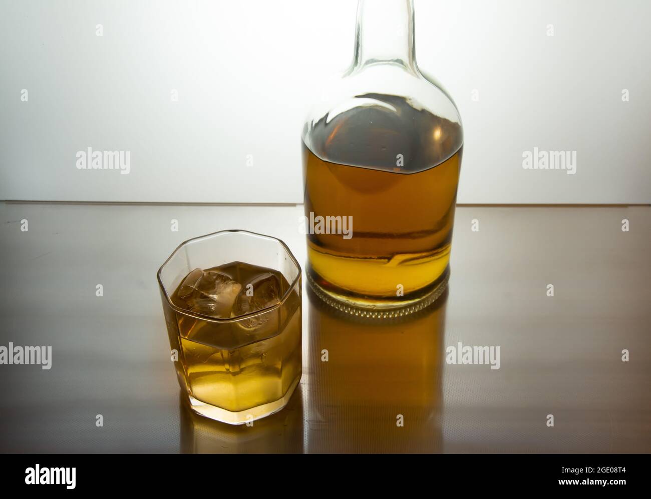 A bottle and a glass of amber-colored whisky on the table Stock Photo ...