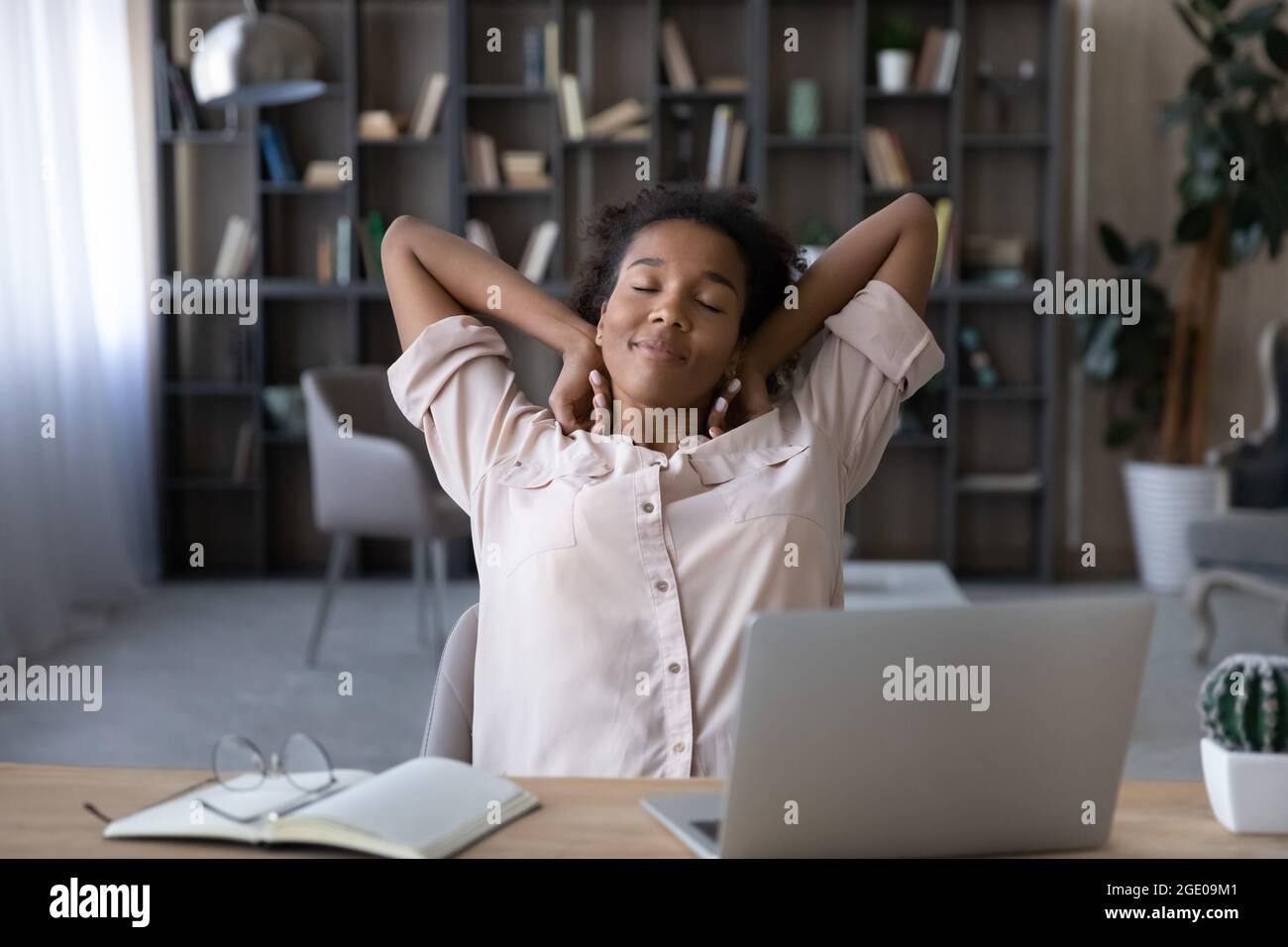 Happy African American woman stretch relax at workplace Stock Photo - Alamy