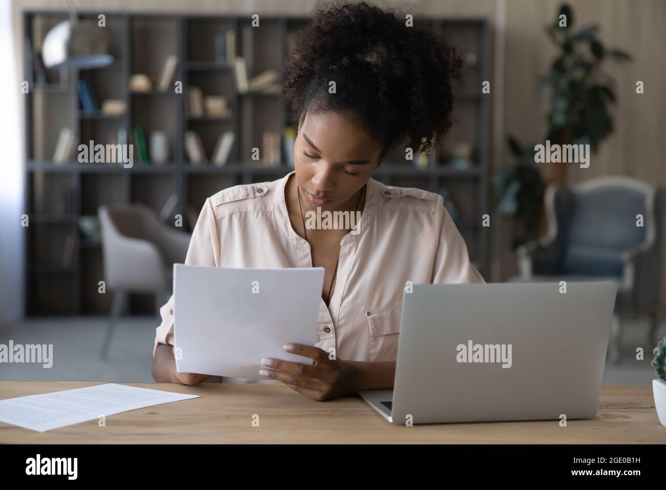 Young ethnic woman work on computer study paperwork Stock Photo - Alamy
