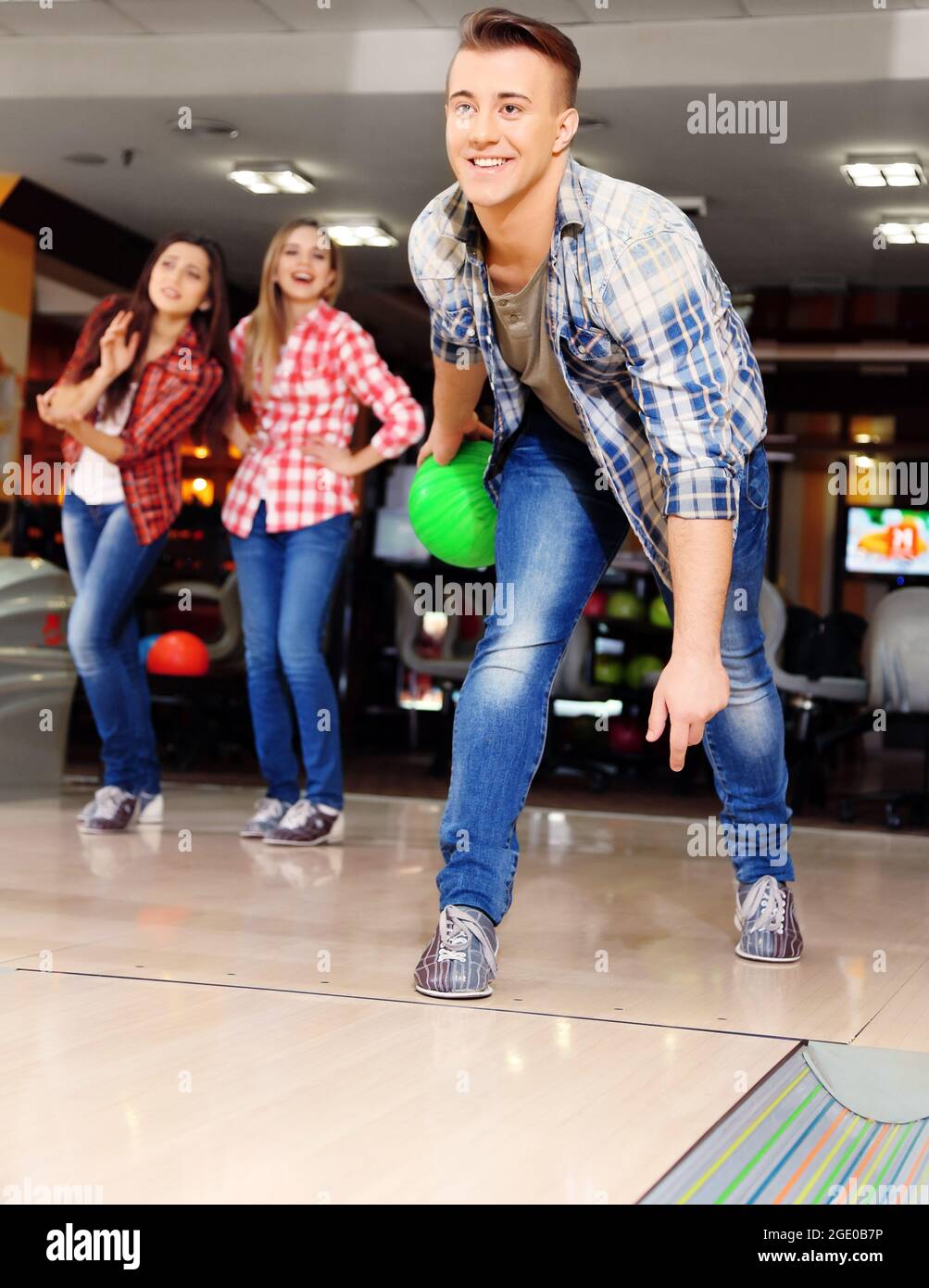 Friends playing in bowling club Stock Photo - Alamy