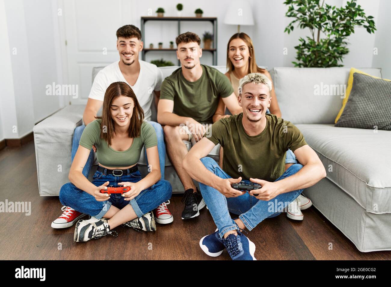 Group of young friends smiling happy playing video game at home Stock ...