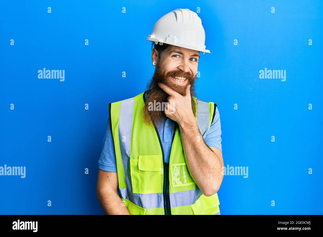 Redhead man with long beard wearing safety helmet and reflective jacket ...