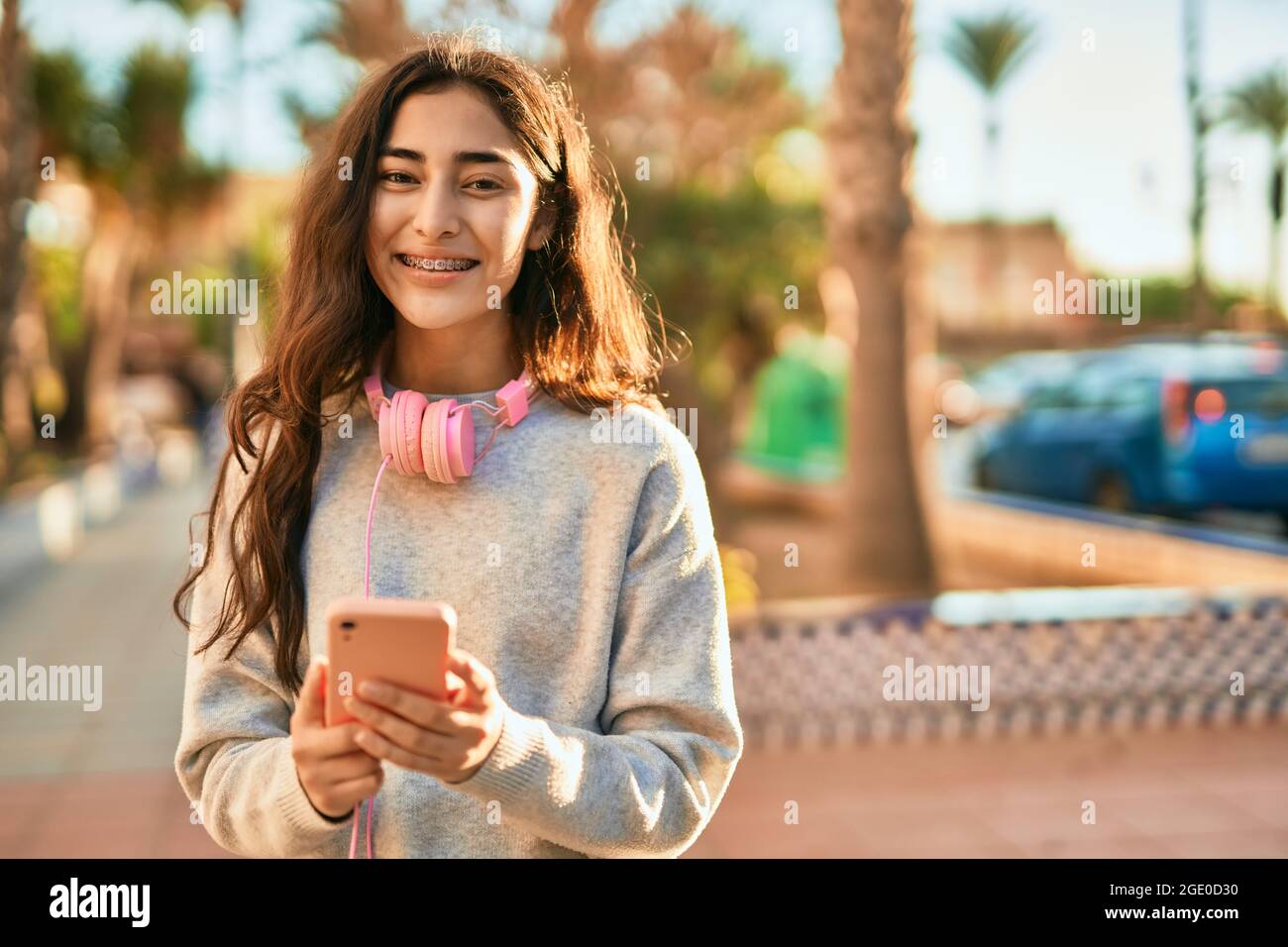 Young middle east girl smiling happy using smartphone and headphones at ...