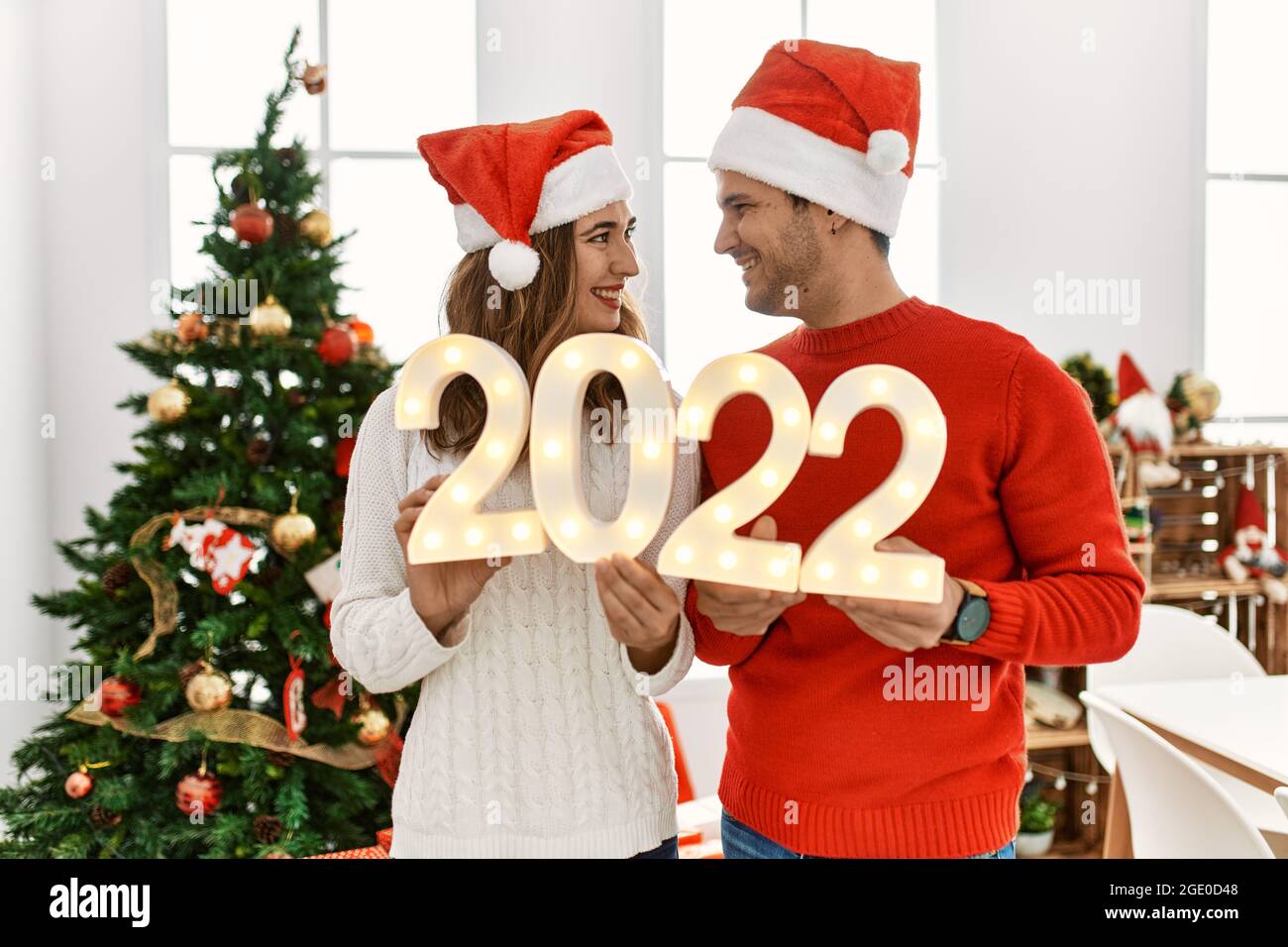 Young hispanic couple smiling happy celebrate new year holding 2022 lights at home Stock Photo ...