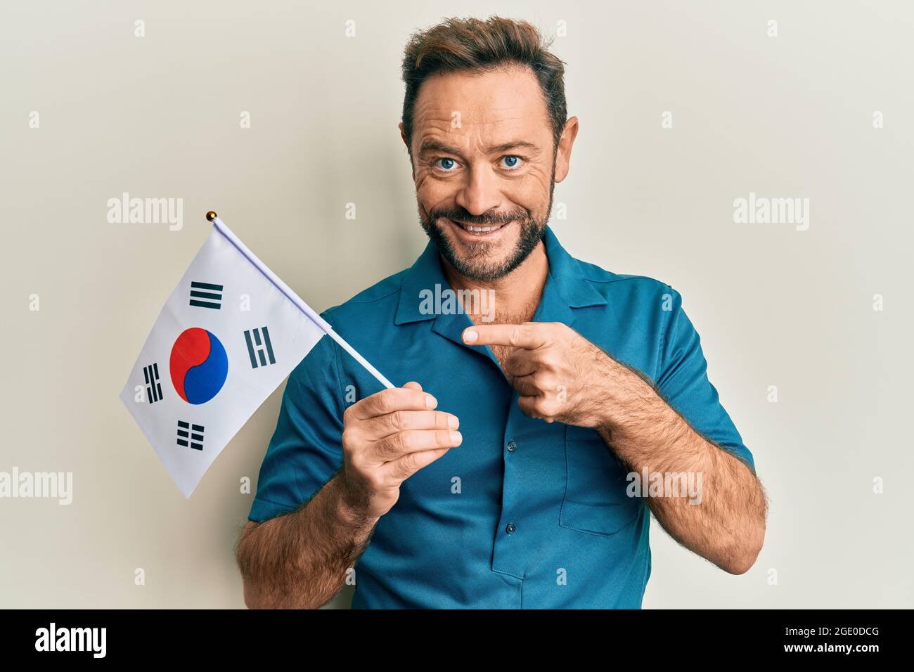 Middle age man holding south korea flag smiling happy pointing with ...