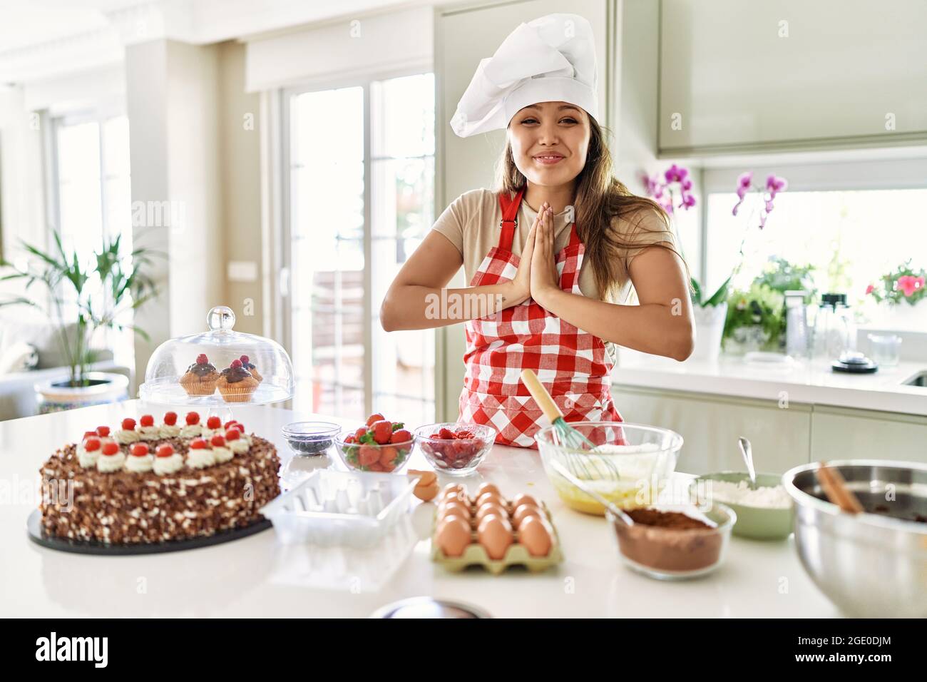 Beautiful young brunette pastry chef woman cooking pastries at the ...