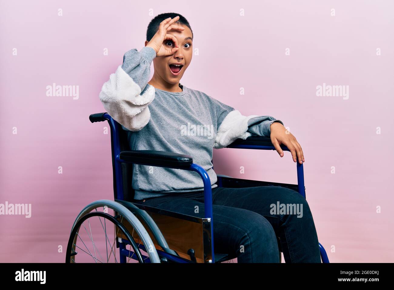 Beautiful hispanic woman with short hair sitting on wheelchair doing ok ...