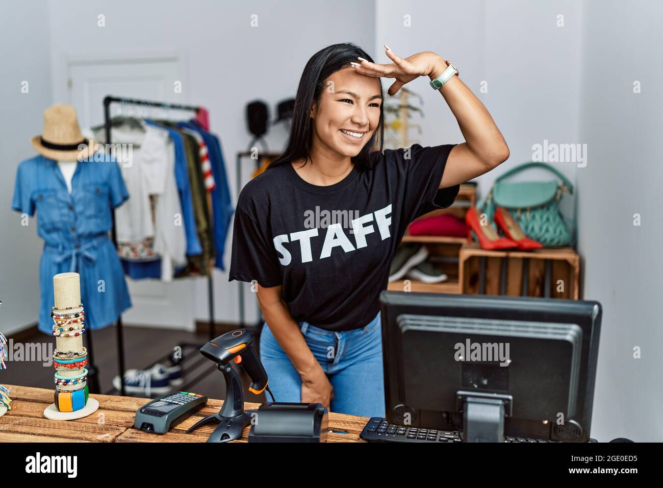 Young hispanic woman working as staff at retail boutique very happy and ...
