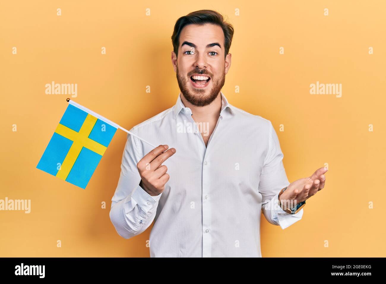 Handsome caucasian man with beard holding sweden flag celebrating ...