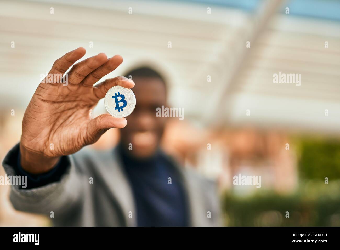 Young african american man smiling happy holding bitcoin at the city ...