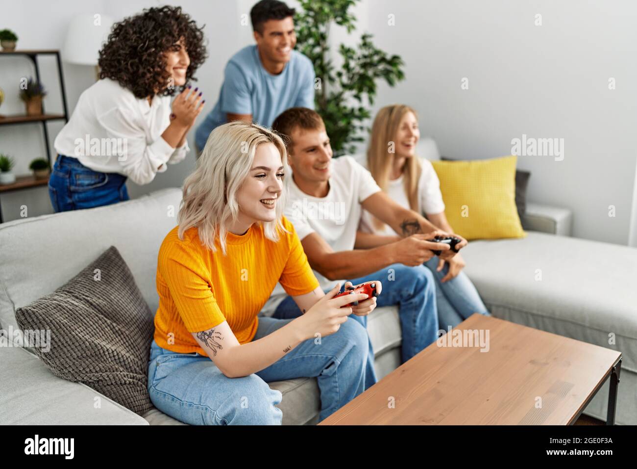 Group of young friends smiling happy playing video game at home Stock ...