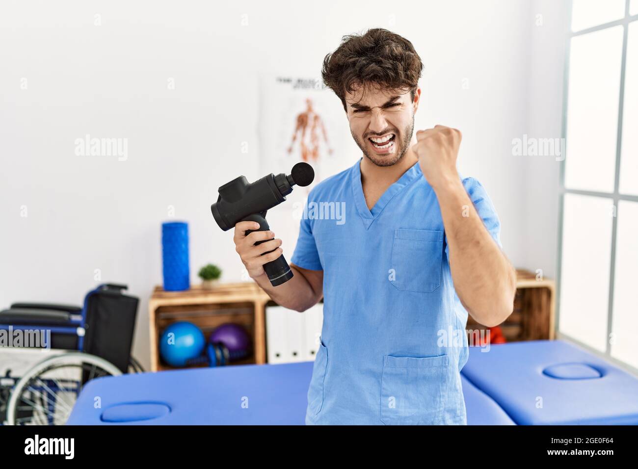 Hispanic physiotherapy man working at pain recovery clinic with muscle ...