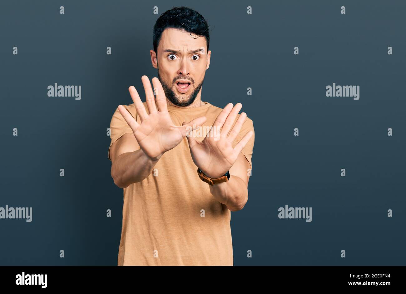 Hispanic man with beard wearing casual t shirt afraid and terrified ...