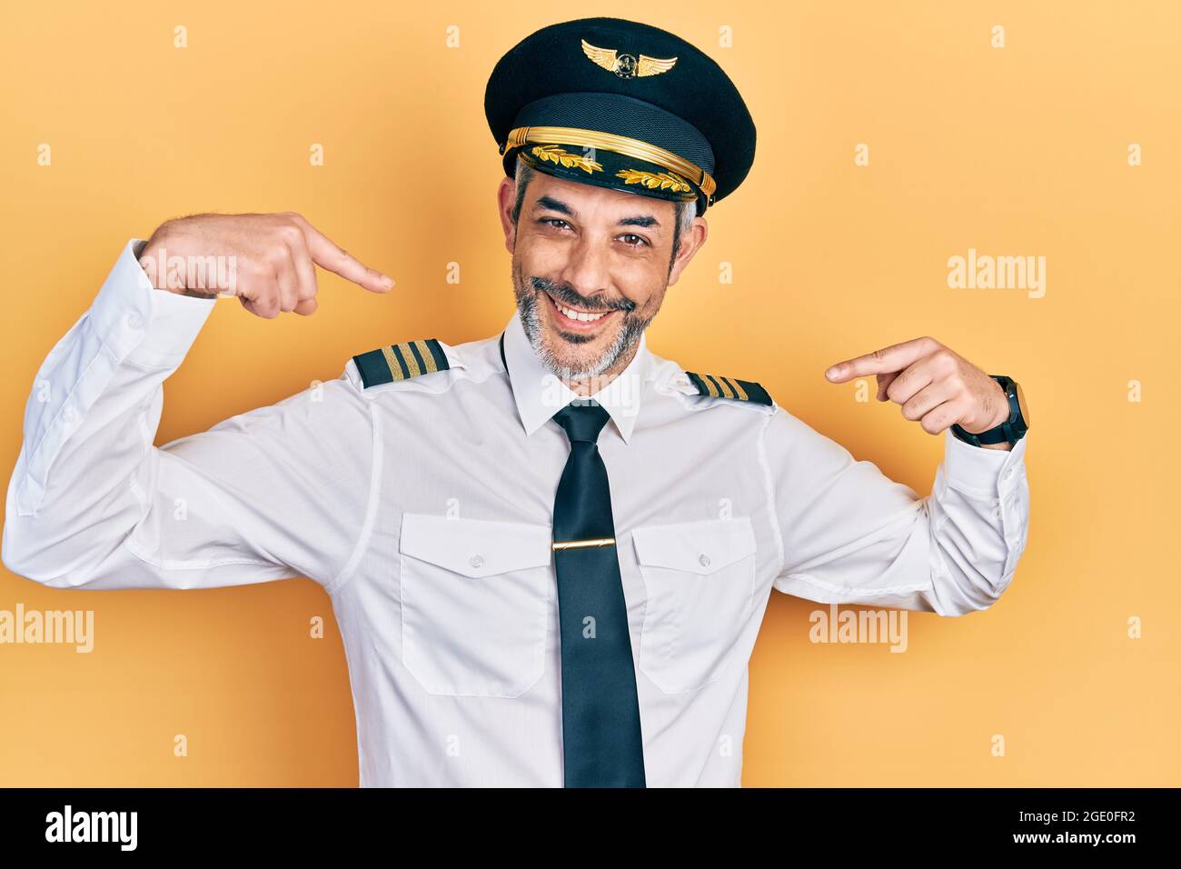 Handsome middle age man with grey hair wearing airplane pilot uniform ...