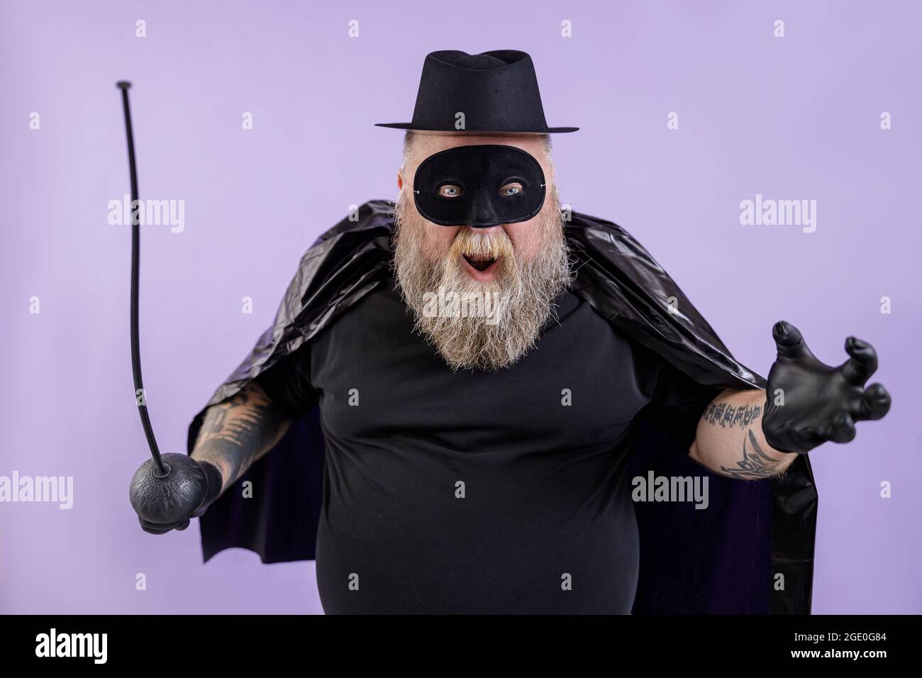 Mature bearded man with overweight wearing Zorro suit with toy epee ...