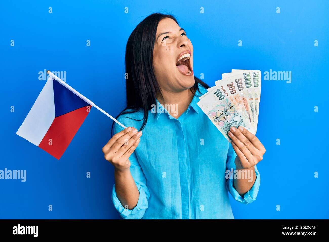 Young latin woman holding czech republic flag and koruna banknotes ...