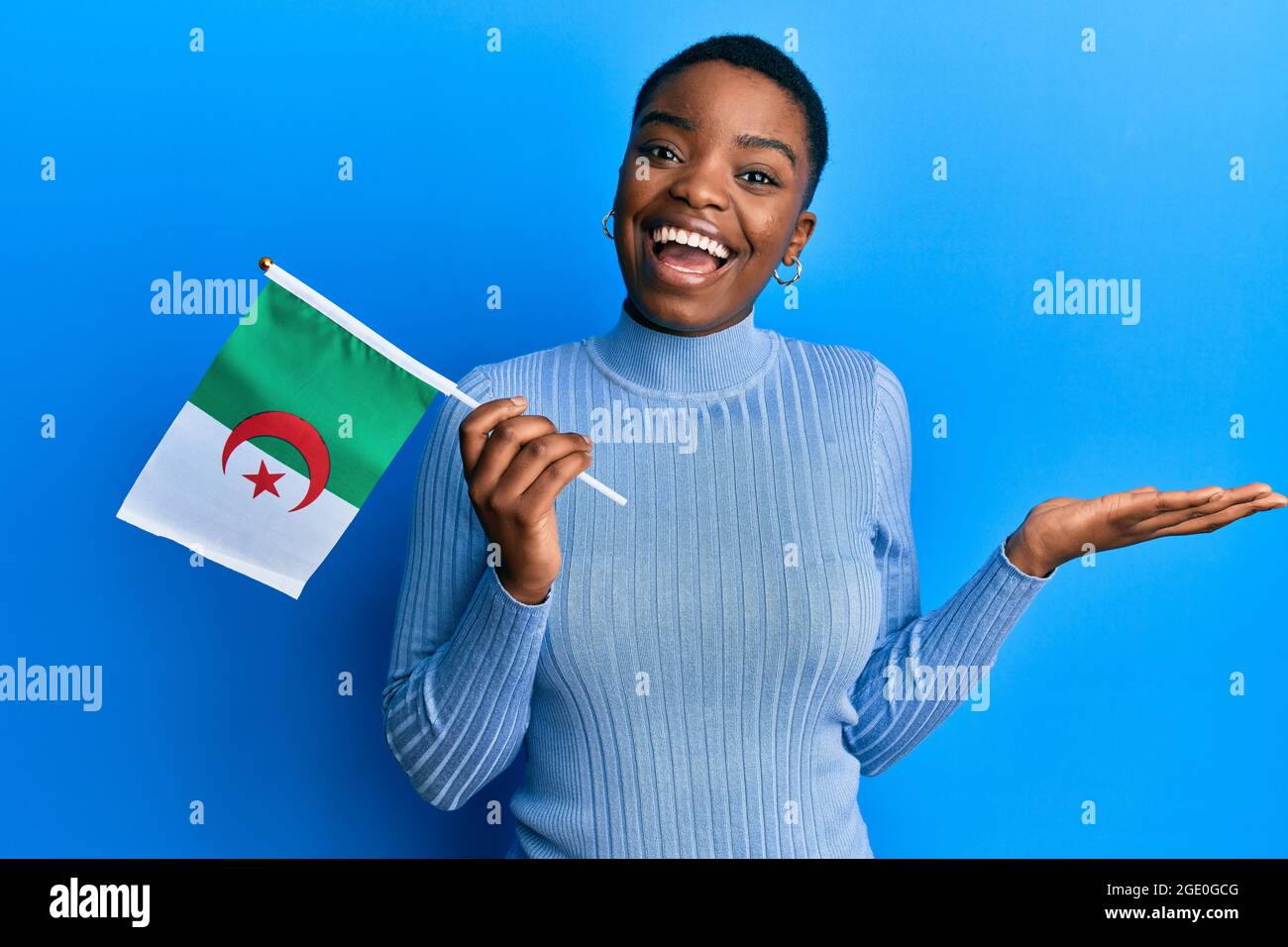 Young african american woman holding algeria flag celebrating ...